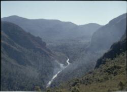 Pieman River? flanked by ridges, with range in distance, Tasmania, ca ...
