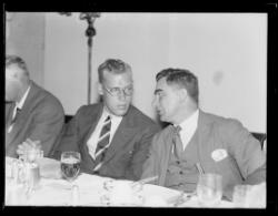 Cricketer William Eric Bowes speaking with man at dining table, New ...